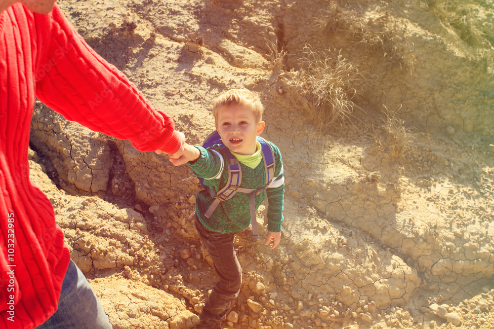 Helping hand- little boy helped by parent in mountains foto de Stock ...