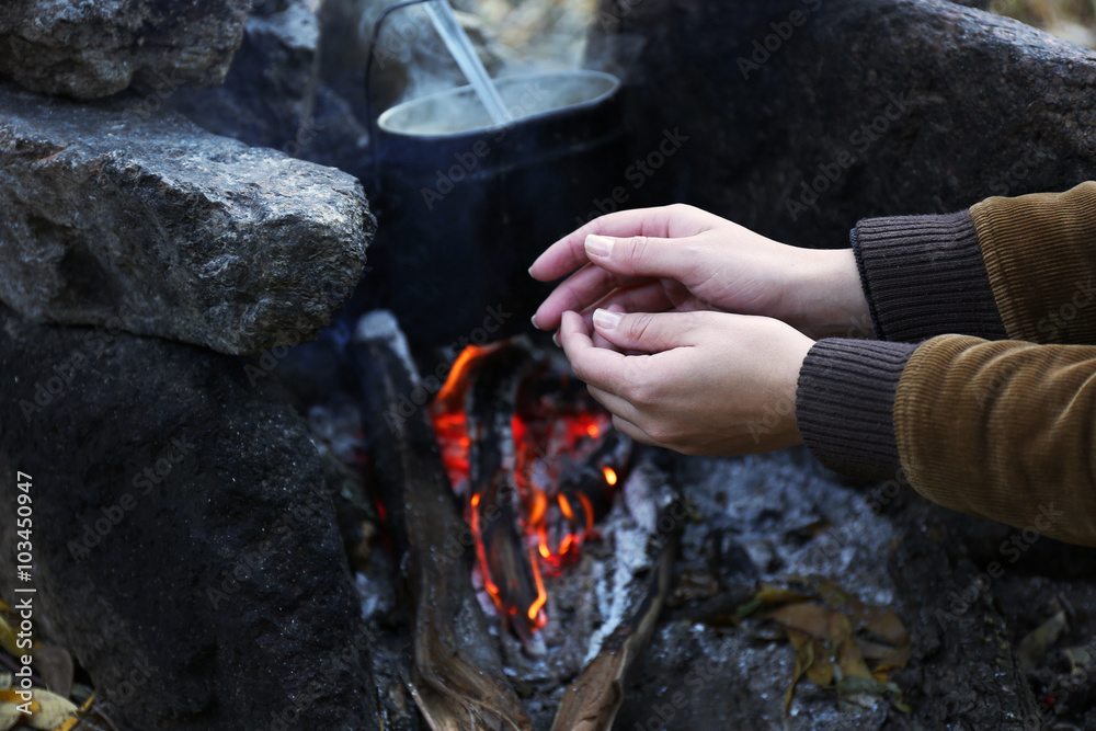 Woman warming hands near the outdoor fire in the nature Stock Photo ...