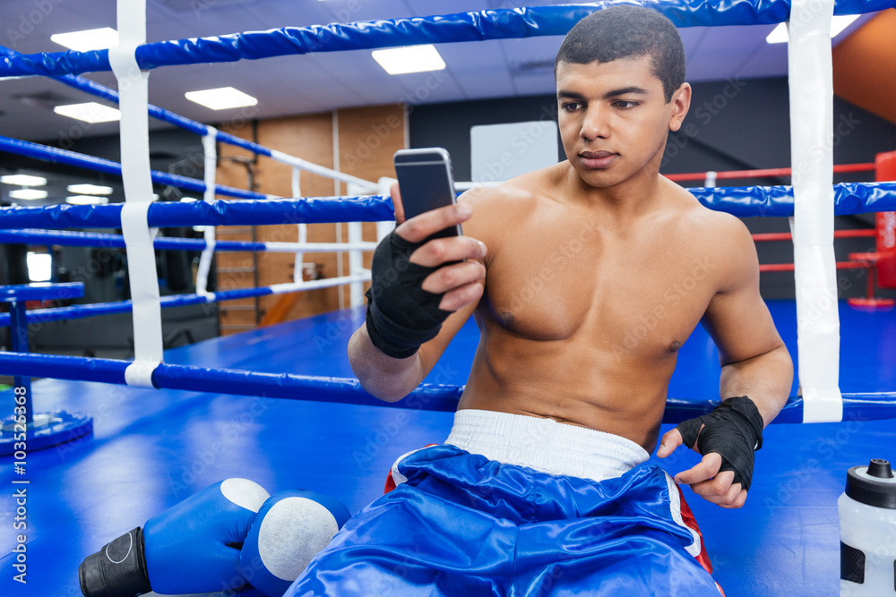 Boxer using smartphone Stock Photo | Adobe Stock