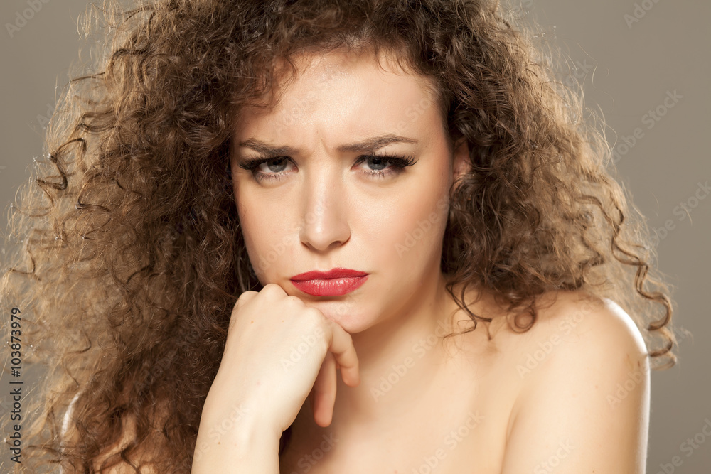 scowling young woman on a gray background Stock Photo | Adobe Stock