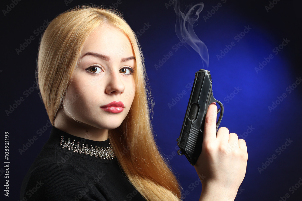 beautiful and serious girl with pistol on dark blue background Stock ...