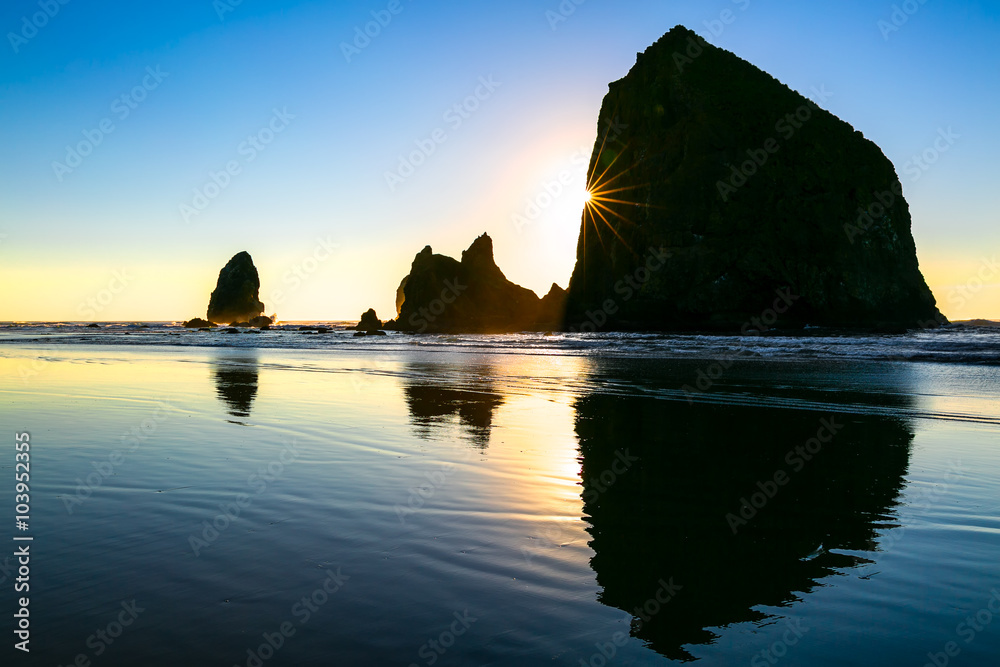 Silhouette of famous sea stack rock formations with natural sun flare ...