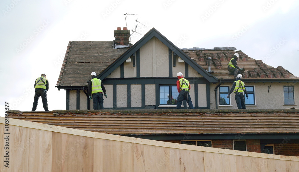 Team of construction workers taking off the roof from building Stock ...