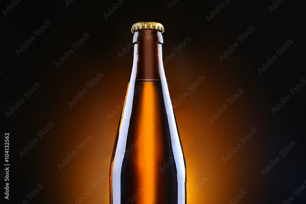 Brown glass bottle of beer on dark lighted background, close up Stock ...