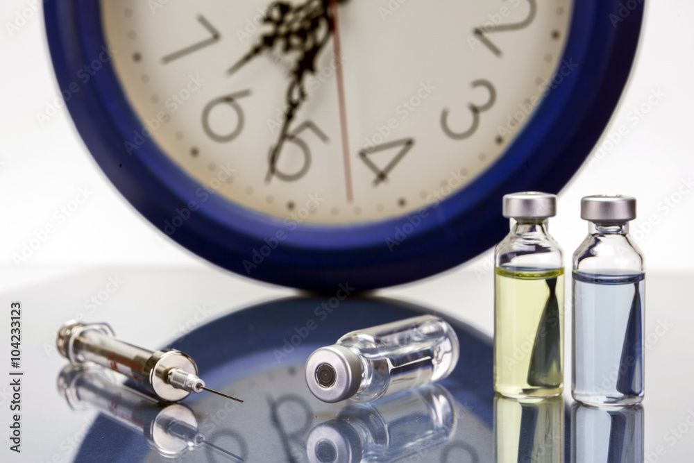 medicine vials and syringe, the clock shows the time of the medi Stock ...