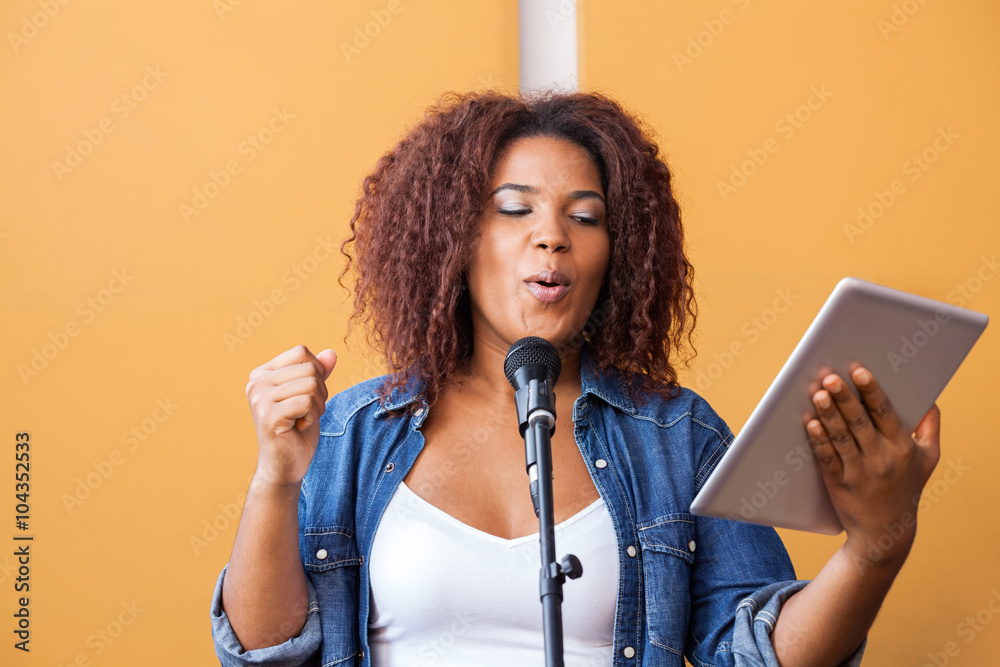 Woman Singing While Holding Digital Tablet Stock Photo | Adobe Stock