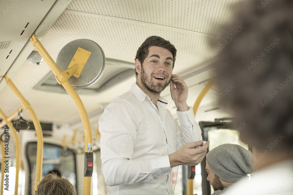 Young man talking on the phone in a city bus Stock-Foto | Adobe Stock