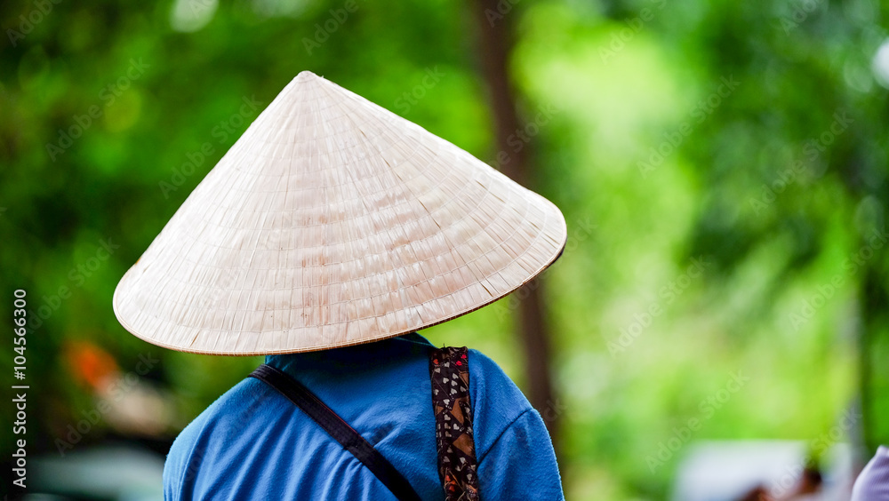 Unidentified woman with conical leaf hat on street in ancient Hoian ...