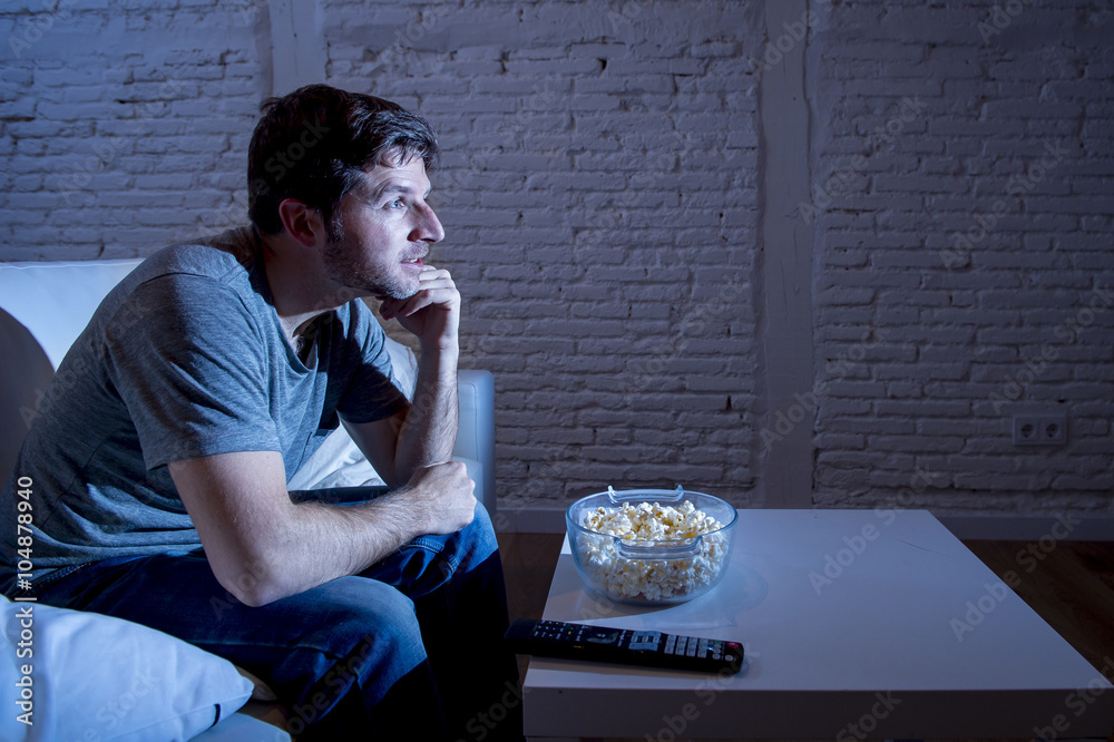 young happy television addict man sitting on home sofa watching TV and ... young happy television addict man sitting on home sofa watching TV and ...