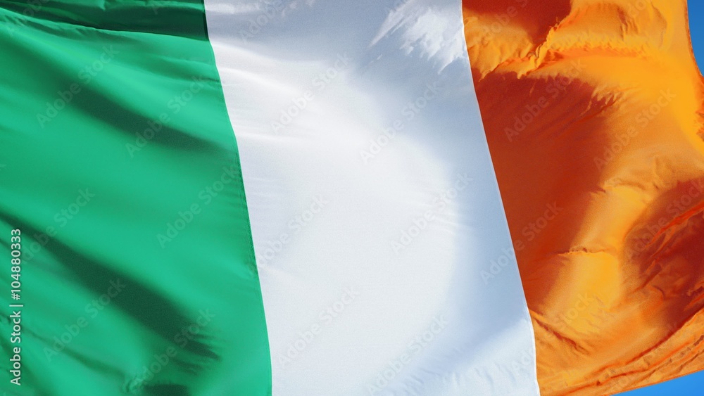 Ireland flag waving in slow motion against blue sky, seamlessly looped ...