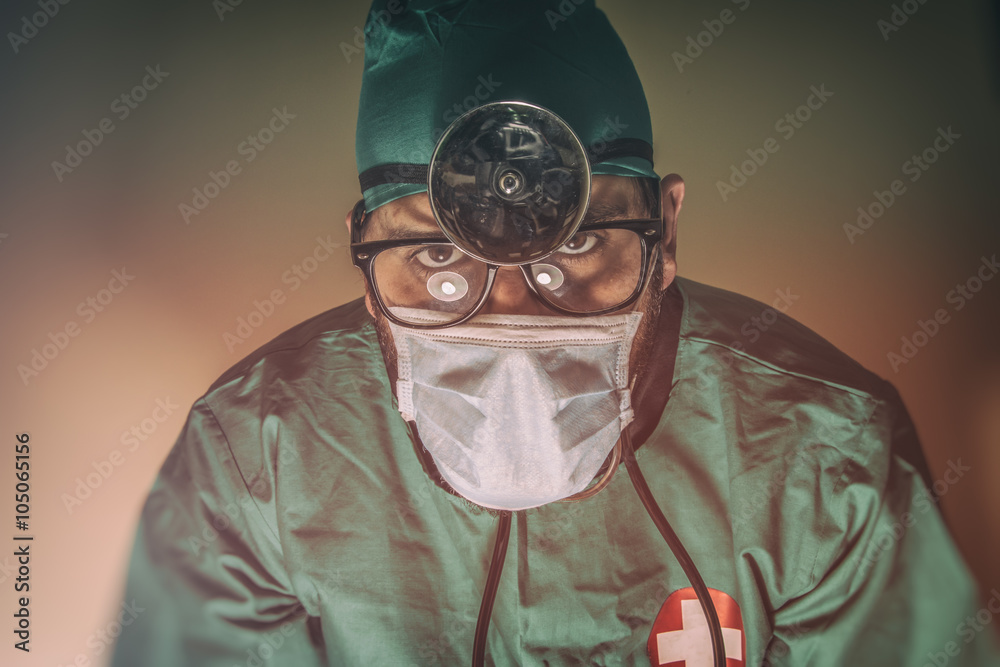 Doctor Takes a Look. Physician wearing scrubs, glasses and wearing head ...