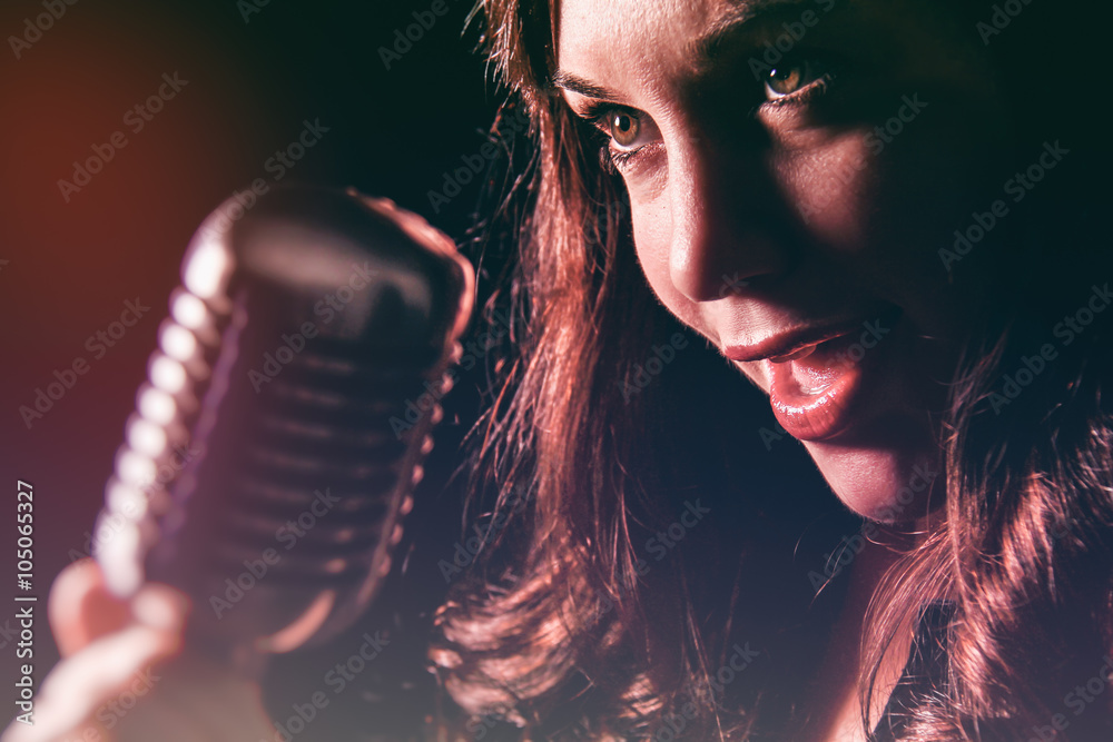 Beautiful Woman with Vintage Microphone. Attractive female singing into ...