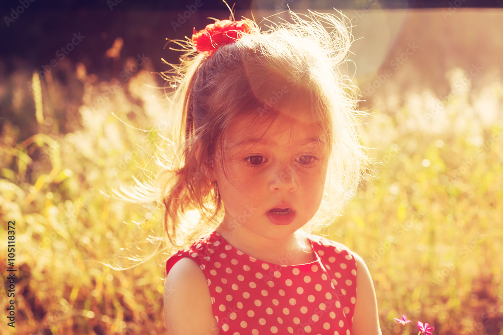Sad Little girl walking on meadow at summer sunset Stock Photo | Adobe ...