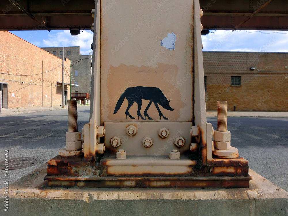 Industrial rusty steel girder with stencil of coyote wearing high heels ...