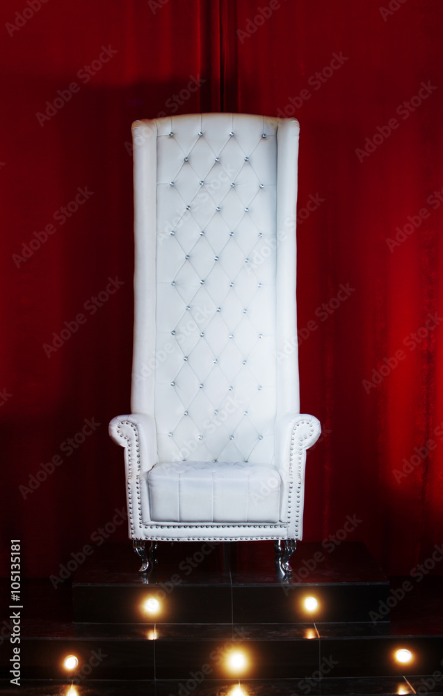 white throne on a red background, chair with high back, elevated ...