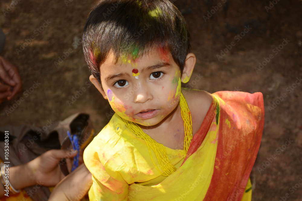 Colors of life. A child is celebrating Holi festival in India. Her face ...