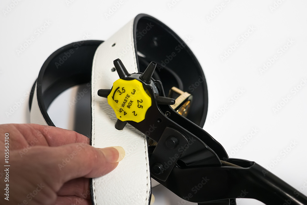 Mit Lochzange ein Loch in einen Gürtel stanzen Stock Photo | Adobe Stock