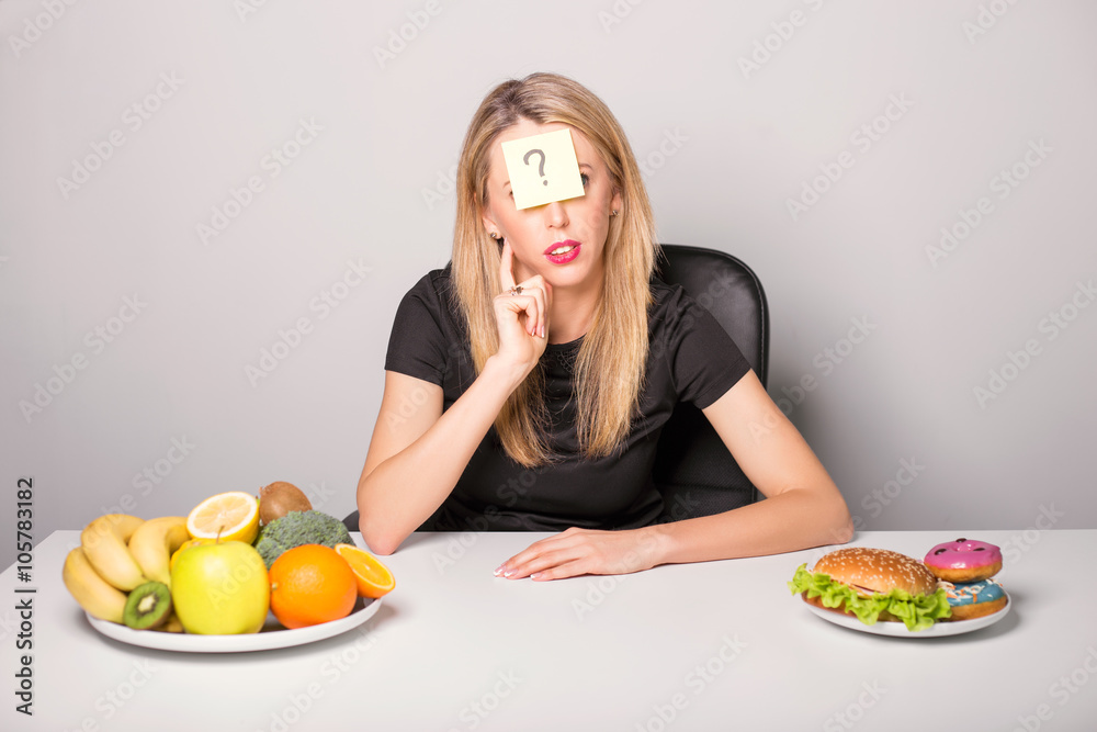 Woman with sticky note and question mark on her forehead choosing ...