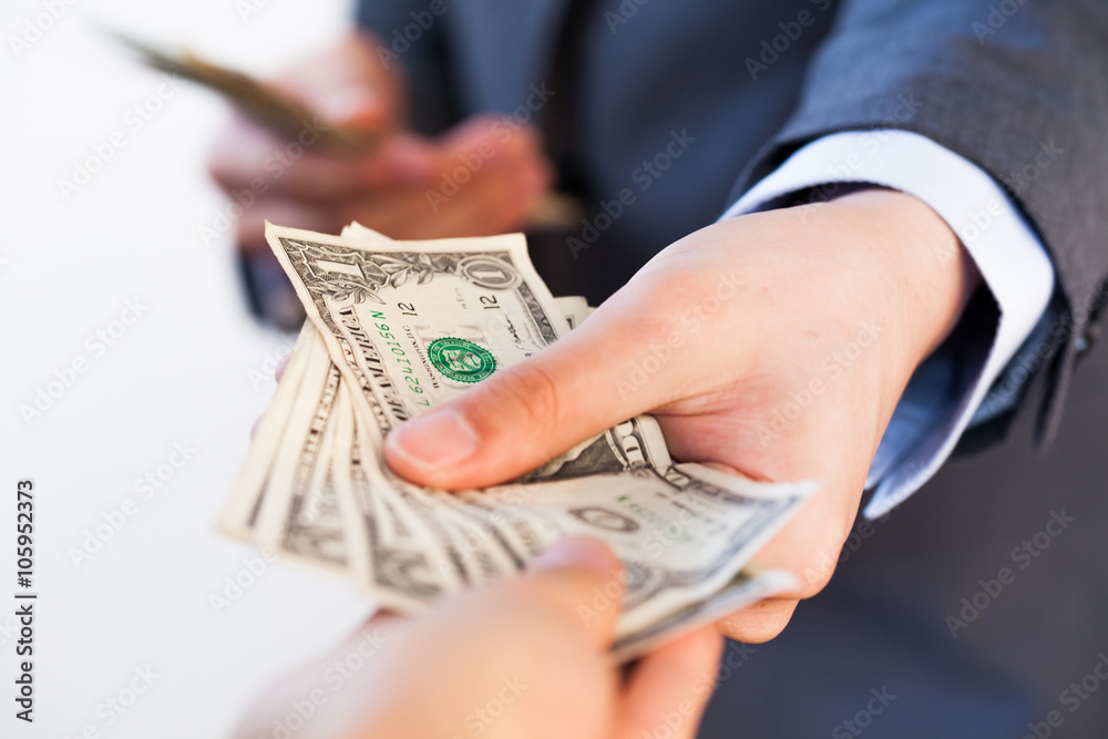 Business man giving bank notes to another person. Corruption and ...