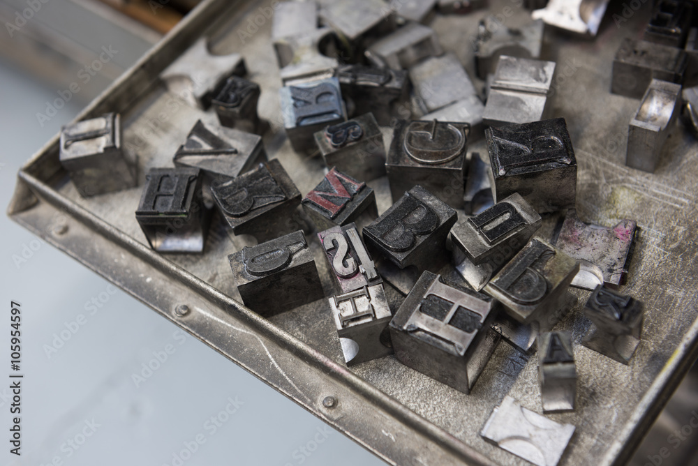 Vintage lead letterpress printing blocks against a weathered metal ...
