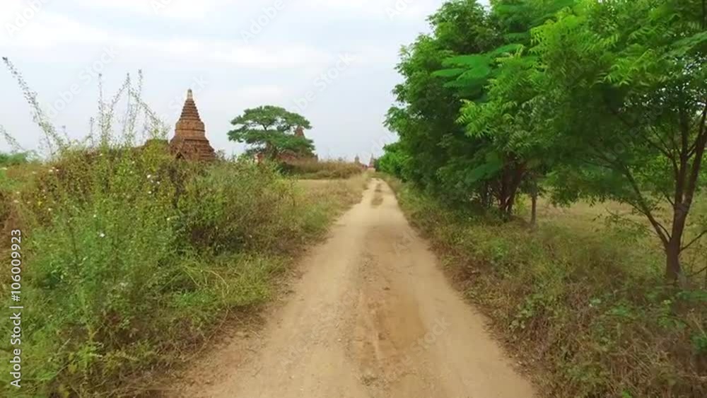 Road ride in Bagan Archaeological Zone with old buddhist temples. Stock ...