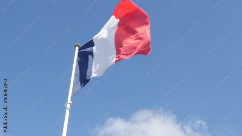 Three color French flag in front of blue sky slow waving on wind 4K ...