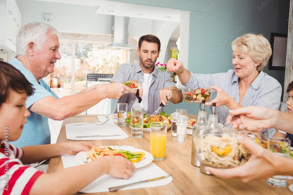 Granny giving food to granddad while sitting at dining table Stock ...