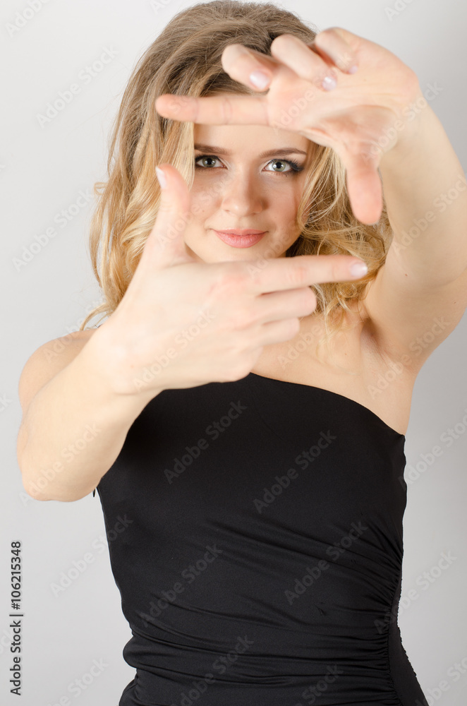 Gesturing finger frame. Beautiful young woman looking at camera and ...