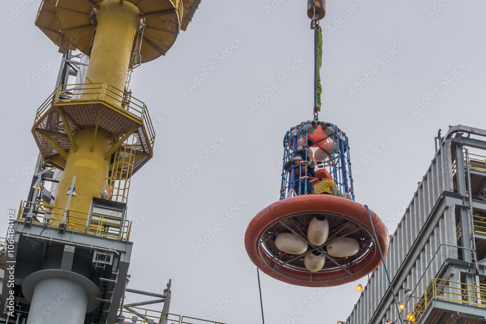 Personal transfer basket. Offshore crew being transferred from oil rig ...