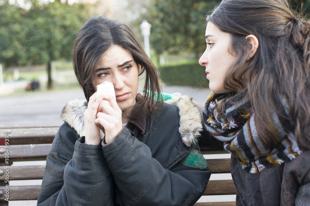 Sad woman crying and friend comforting in the park. Stock Photo | Adobe ...