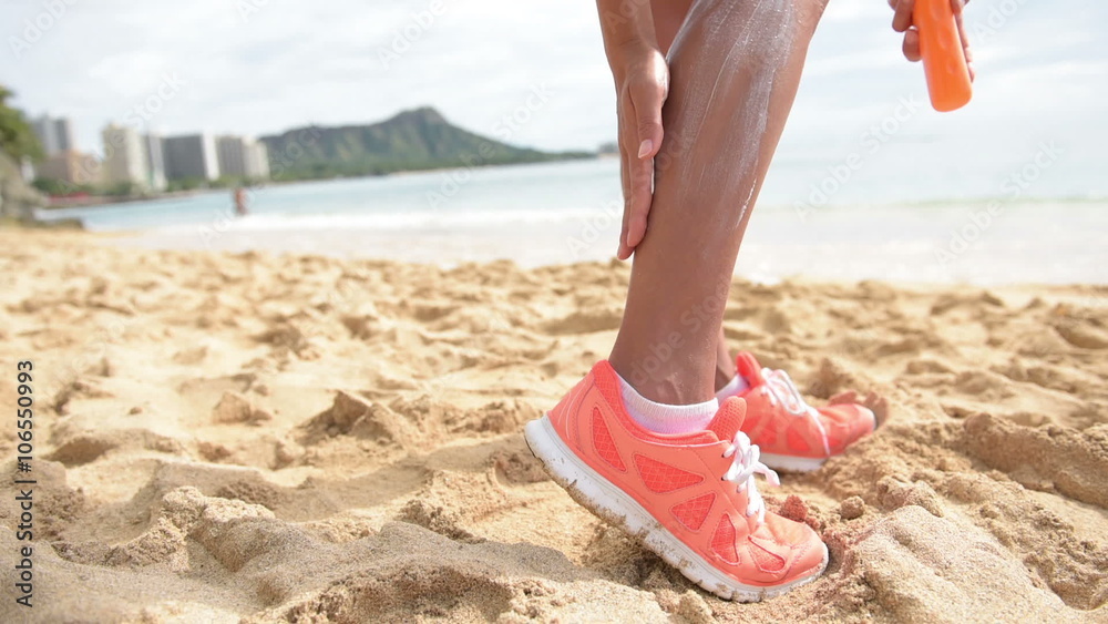 Sun screen lotion on beach - runner athlete woman applying sunscreen ...