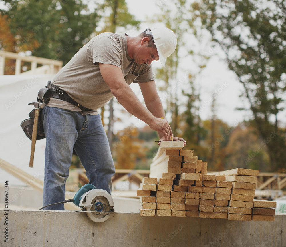 Caucasian construction worker marking wood planks Stock Photo | Adobe Stock