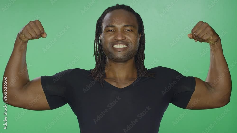 Athletic black man flexing his arms, on a green screen studio ...