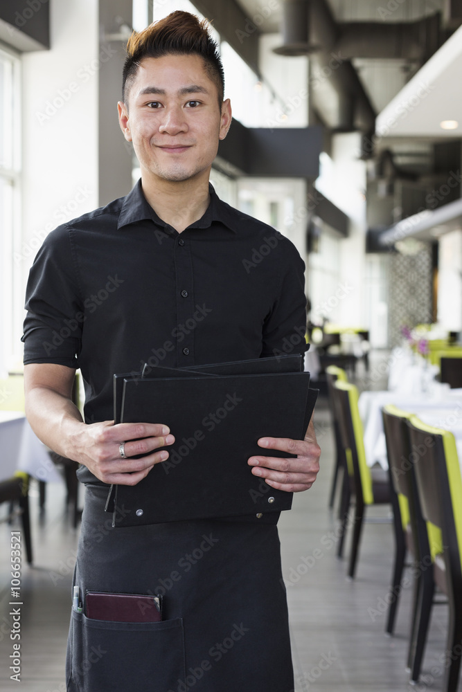 Asian waiter standing in restaurant Stock Photo | Adobe Stock