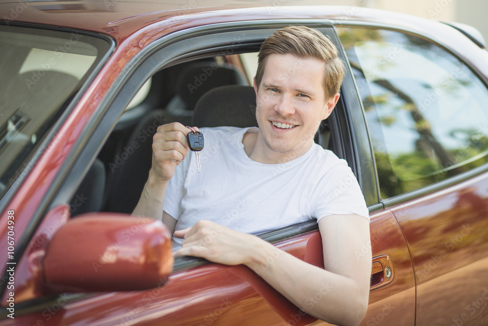 Junger Mann sitzt im Auto und zeigt seine Autoschlüssel Stock Photo ...