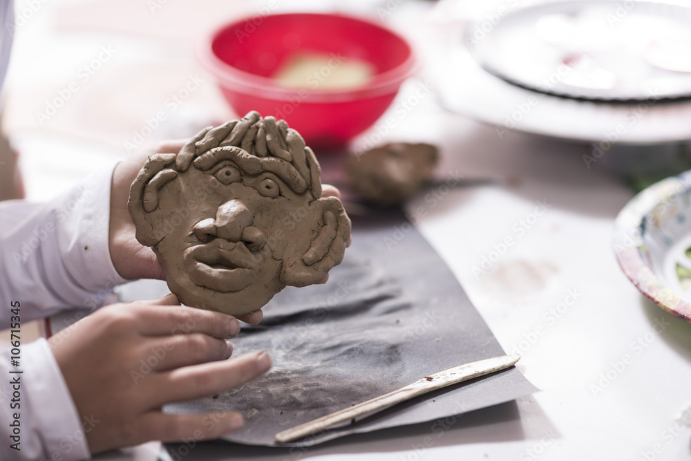 Boy making face from modeling clay in art class at school Stock Photo ...