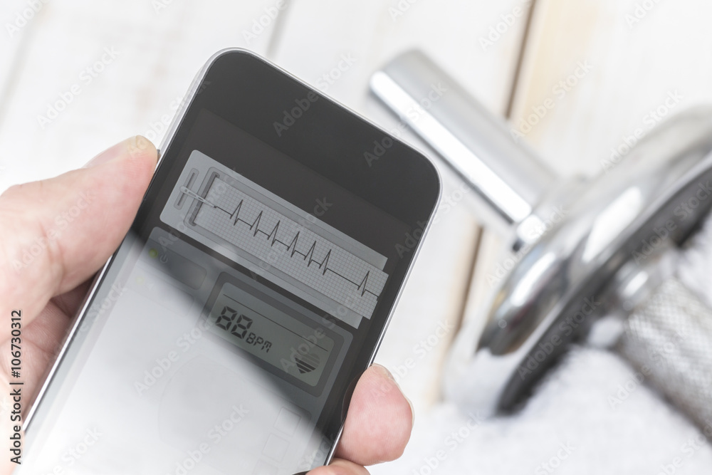 Hand holding smartphone with heart rate monitor showing cardiac ...