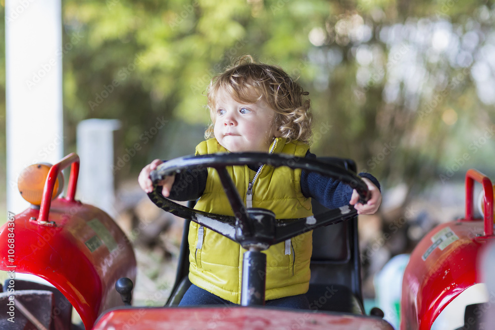 Caucasian baby boy driving tractor Stock Photo | Adobe Stock