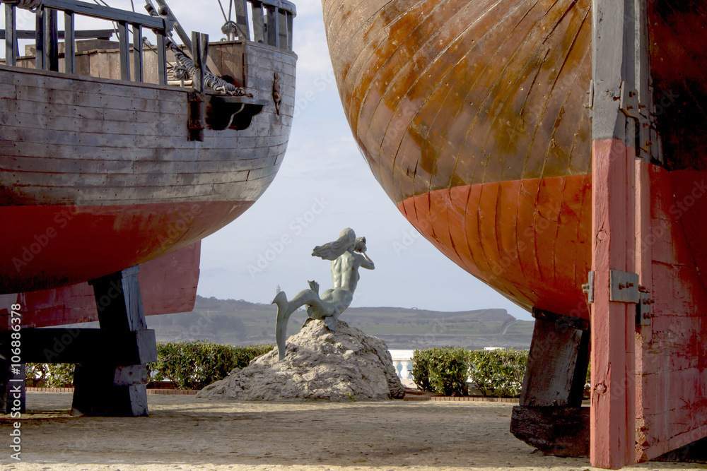 Statue of a mermaid between two old Spanish wooden ships exposed Stock ...