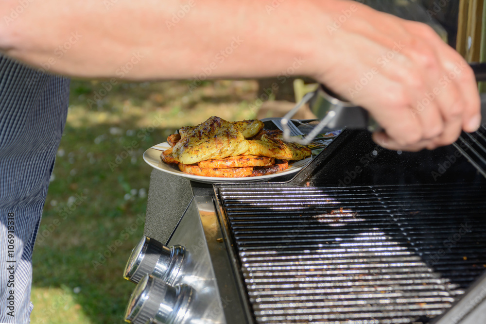Mann am Grill mit der Grillzange in der Hand im Garten Stock Photo ...