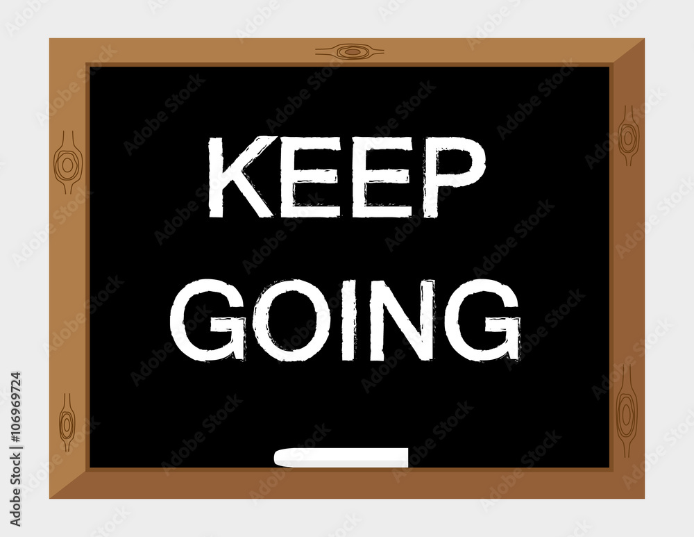 The words Keep Going in white text on a blackboard with a stick of ...