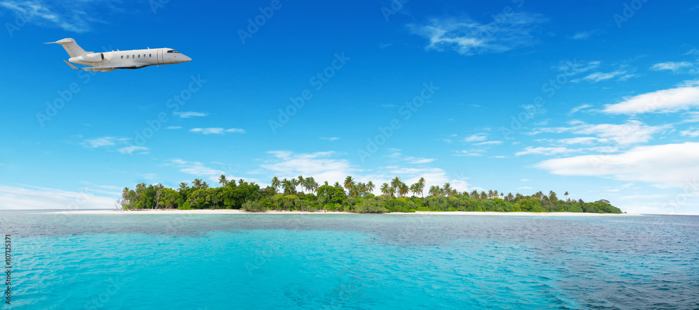 Airplane flying over nonsettled tropical island Stock Photo | Adobe Stock