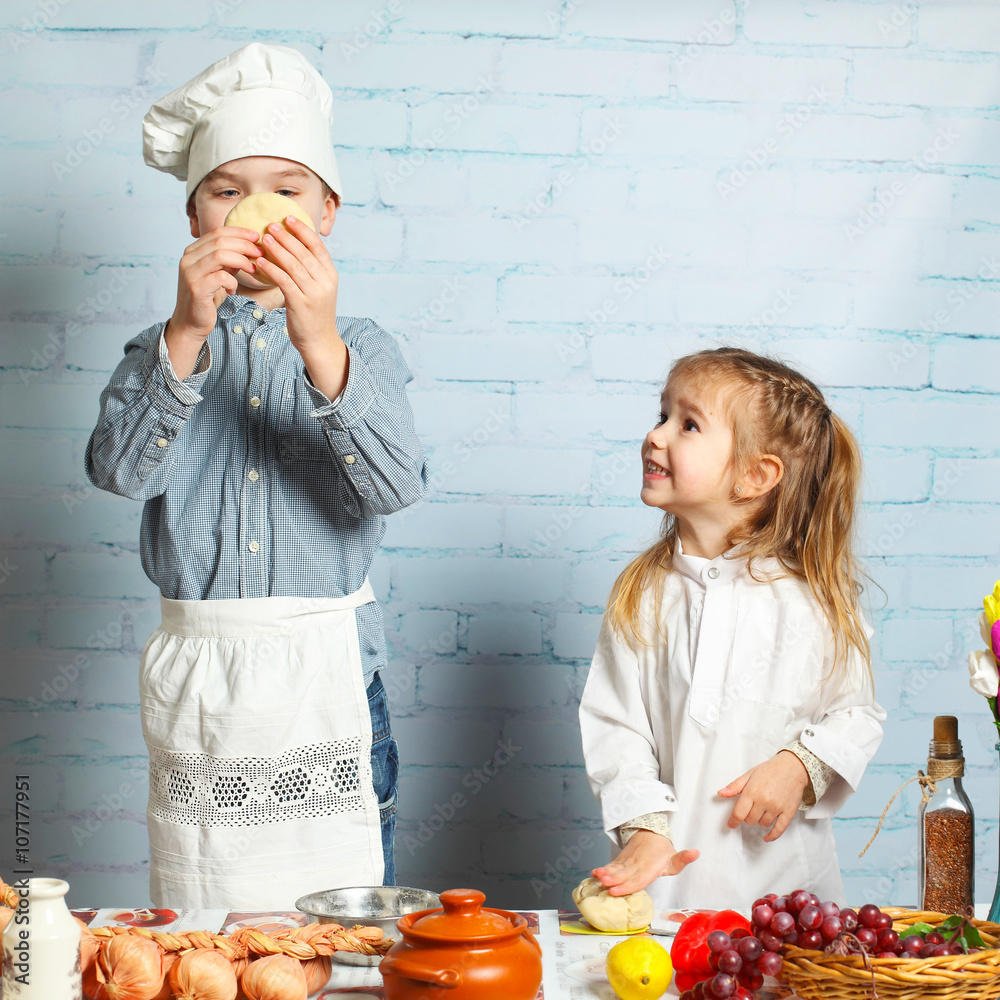 Children chefs. little brother and sister cook in the kitchen. Little ...