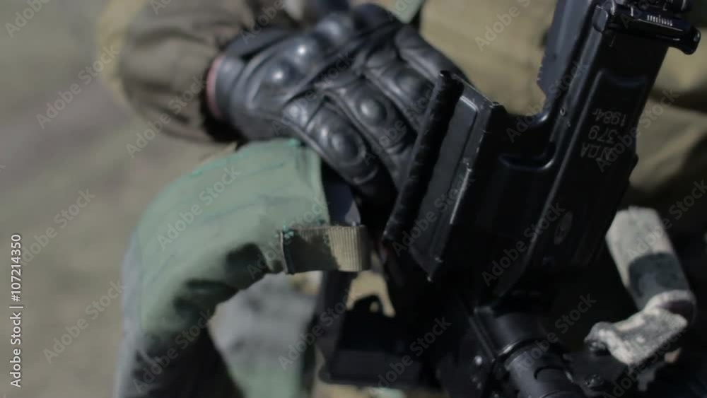 A soldier with a machine gun at a military training ground during the ...