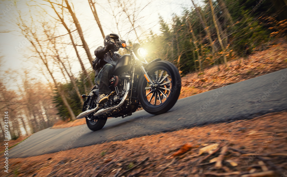 Young man riding chopper on road in forest Stock-Foto | Adobe Stock