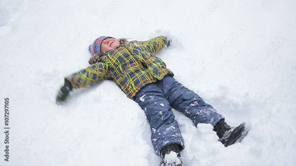 Boy making a snow angel Stock Video | Adobe Stock