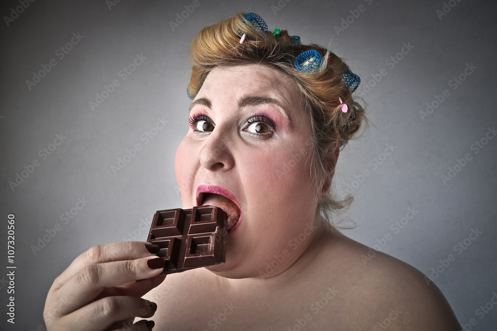 Chubby woman eating chocolate Stock-Foto | Adobe Stock