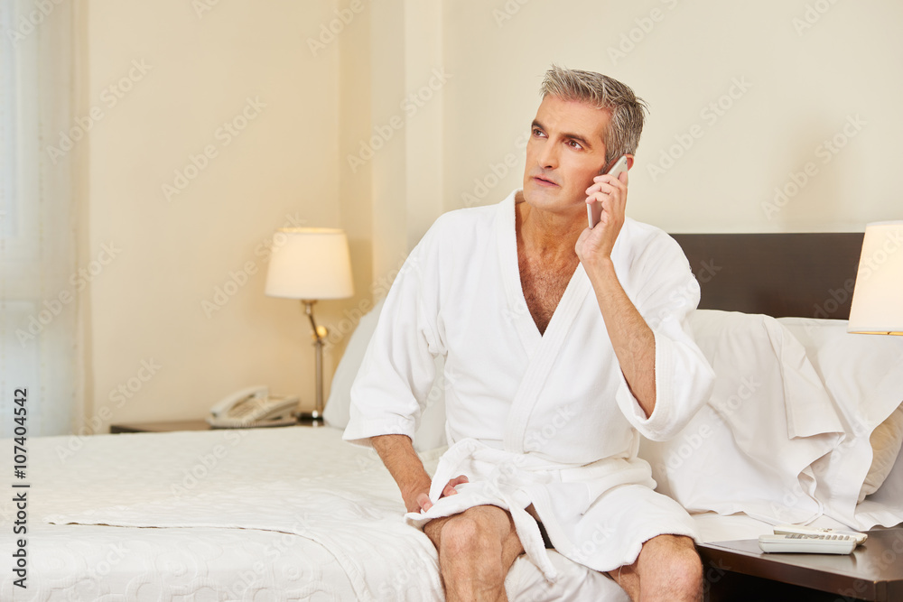Mann telefoniert im Hotelzimmer Stock-Foto | Adobe Stock
