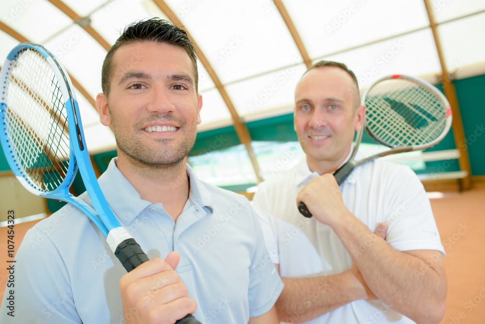 Two men with tennis rackets on their shoulders Stock Photo | Adobe Stock