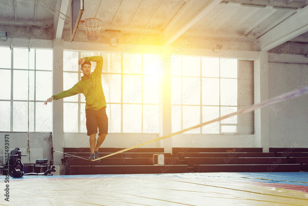 Foto de Man slacklining walking and balancing on a rope, slackline in a ...
